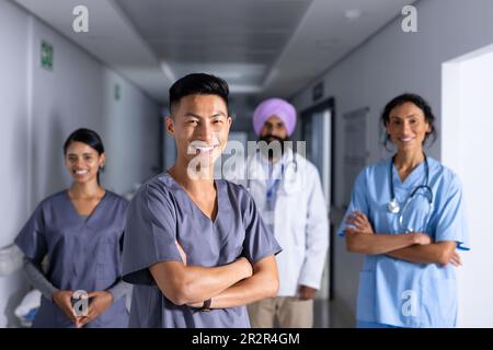 Portrait of happy diverse doctors standing in corridor at hospital ...