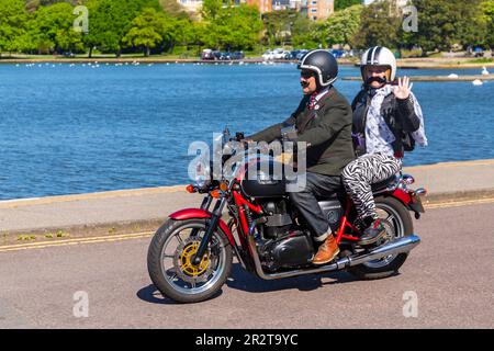 People ride motorcycles through red brick buildings in the Chinese and ...