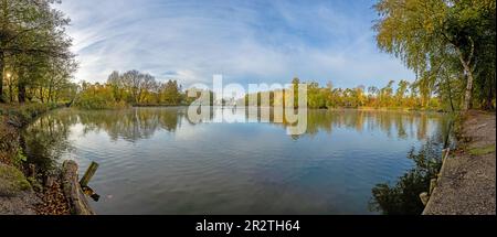 Panoramic image over pond during sunrise in autumn with early morning ...