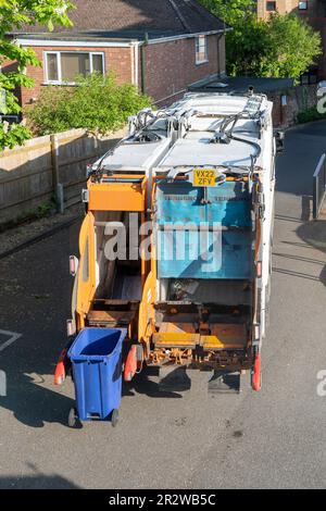 A refuse collection vehicle emptying bins in a housing estate in ...