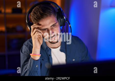 Young caucasian man streamer stressed using computer at gaming room ...
