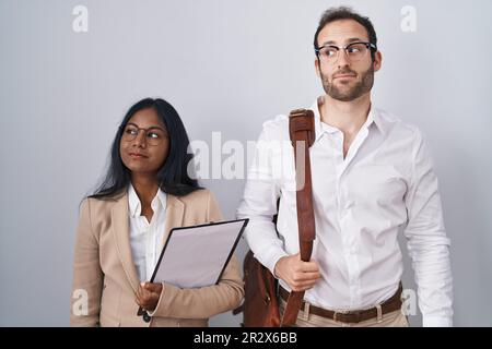 Interracial business couple wearing glasses covering one eye with hand ...