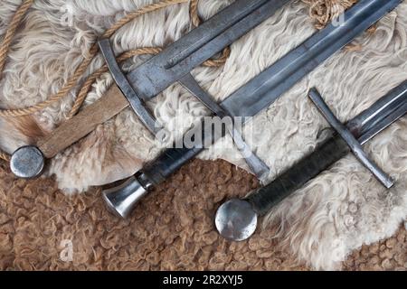 Medieval swords on sheep fur background Stock Photo - Alamy