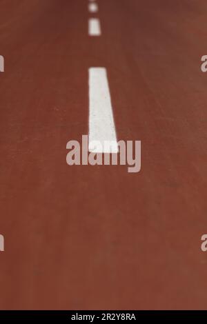 New red bikepath or pedestrian path separated by white line, traffic ...