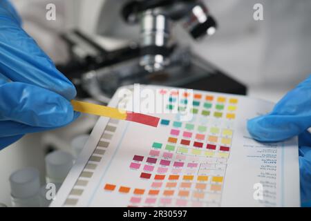 Laboratory worker compares color of stick with indicators Stock Photo ...