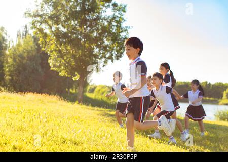 Cheerful Chinese school children relaxing in park Stock Photo - Alamy