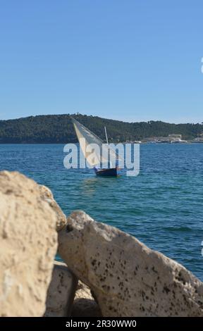 Traditional Provencal boat entering under sail at the small port of St ...