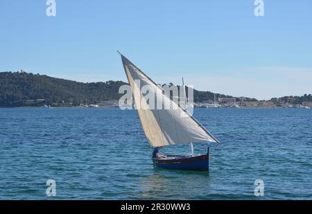 Traditional Provencal boat entering under sail at the small port of St ...