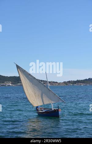 Traditional Provencal boat entering under sail at the small port of St ...