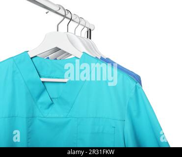 Turquoise and light blue medical uniforms on rack against white ...