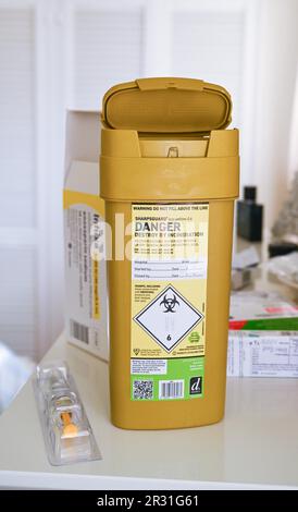 Sharps bin for disposing safely of needles Stock Photo - Alamy