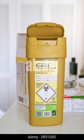 Sharps bin for disposing safely of needles Stock Photo - Alamy