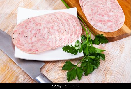 European cuisine raw sausage served with parley on white plate on ...