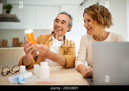 Senior couple with pills using laptop Stock Photo - Alamy
