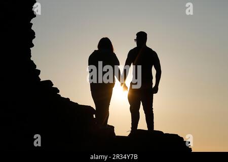 A romantic couple stand at Sandal Castle to watch the sun set Stock ...