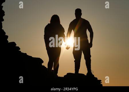 A romantic couple stand at Sandal Castle to watch the sun set Stock ...