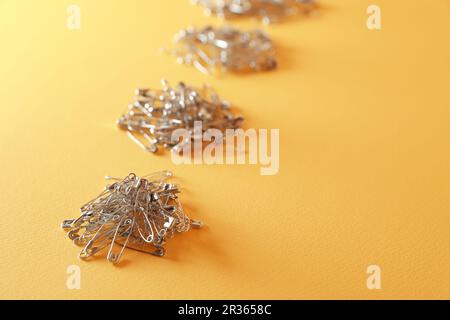 Piles of safety pins on yellow background, space for text Stock Photo ...