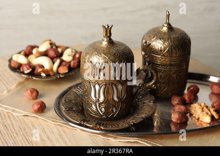 Tea and nuts served in vintage tea set on wooden table, space for text ...