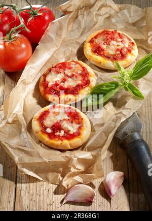 Small pizzas on baking paper close up Stock Photo - Alamy