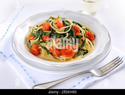 Fried spaghetti with dandelions, tomatoes and chilli Stock Photo - Alamy
