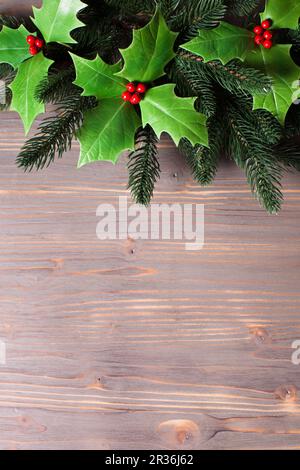Holly and fir twigs on wood wall Stock Photo - Alamy