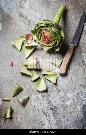 fresh baby artichoke with leaves on rustic wooden background Stock ...