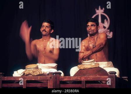 Playing the Mizhavu, a copper drum covered with animal skin during ...