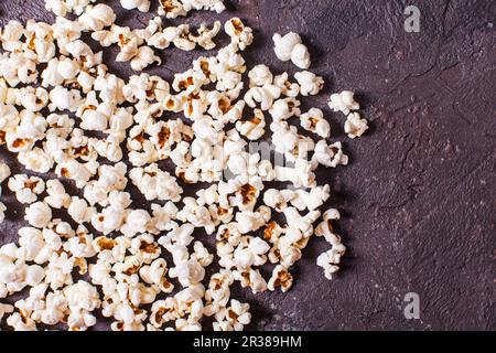 Snack concept, Sweet popcorn spilled out from paper cup on red ...