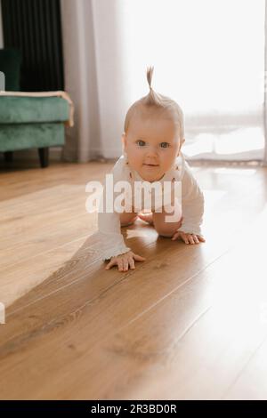 Crawling baby on the wooden floor in the room Stock Photo - Alamy