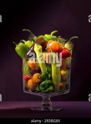 Different types of peppers in a glass plate. White background. Macro ...