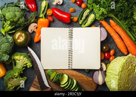 Empty paper notepad and assorted fresh vegetables on rustic concrete ...