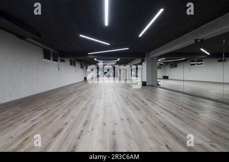 An empty dance hall with a glass wall adorned with decorative graffiti ...