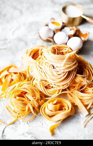 Various types of fresh homemade pasta. Raw pasta drying process ...