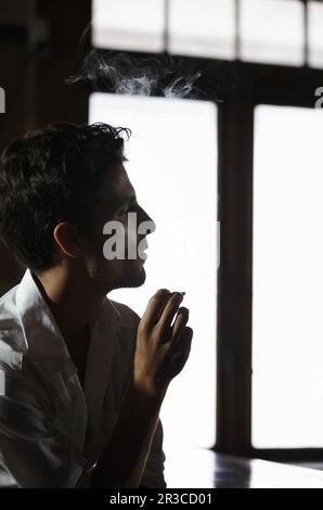 Young man smoking addiction problems sitting at table smoking and ...
