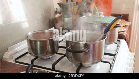 Steam coming out of pots and pans. Red hot stove under the pan. Home ...