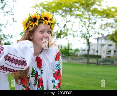 Ukrainian girl in a wreath of sunflowers in a field of sunflowers ...