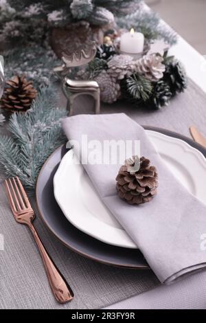 Beautiful table setting with pine cones, blank card and fir branches ...
