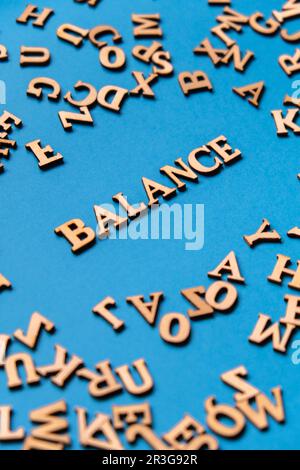 Word BALANCE made out of wooden letters on bright blue background ...