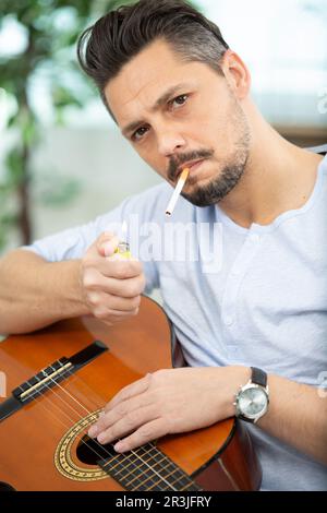 Portrait of man with cigarette, grunge fashion and rockstar attitude on ...
