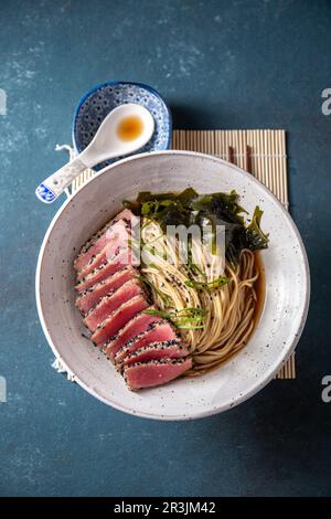 Tuna steak ramen. Japanese soup with noodles ramen, miso, fried tuna steak and seaweed algae ...