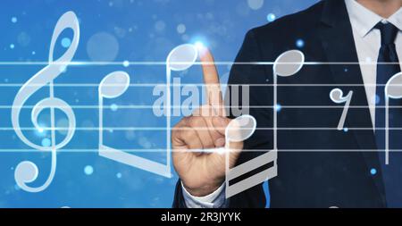 Musician pointing at staff with music notes and symbols on color ...