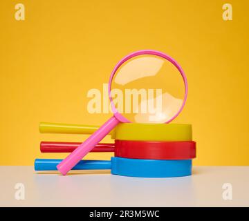 Stack of plastic magnifiers on yellow background Stock Photo - Alamy