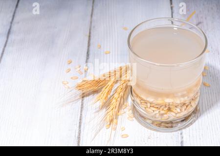 Simple barley orzo infused water drink in glass, with raw and cooked ...