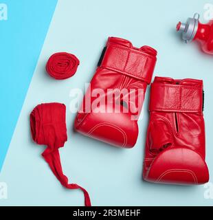Red leather boxing gloves, water bottle. Sports equipment on a yellow ...