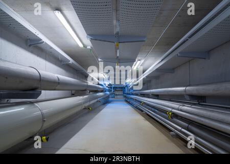 Empty underground corridor with drainage system and metal pipelines for ...