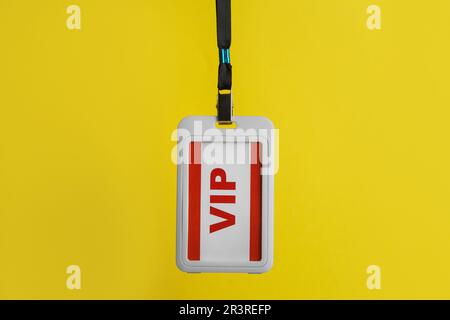 White plastic vip badge hanging on red background, space for text Stock ...