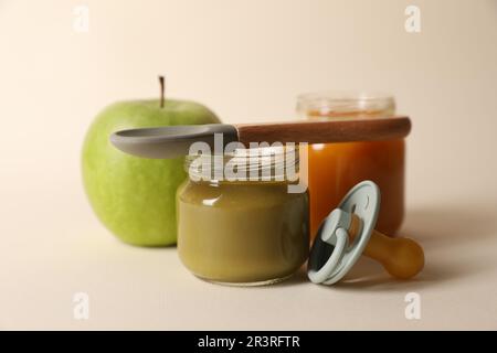 Healthy baby food, apple and pacifier on light grey background Stock ...