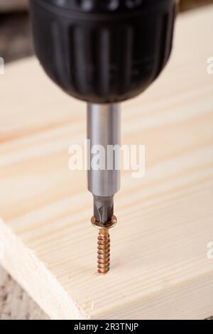 Screwdriver driving a screw into wood Stock Photo - Alamy
