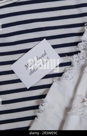 MAKE LOVED CLOTHES LAST text on paper note on clothes assortment Second ...
