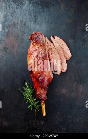 Traditional barbecue leg of venison sliced and served as top view on ...